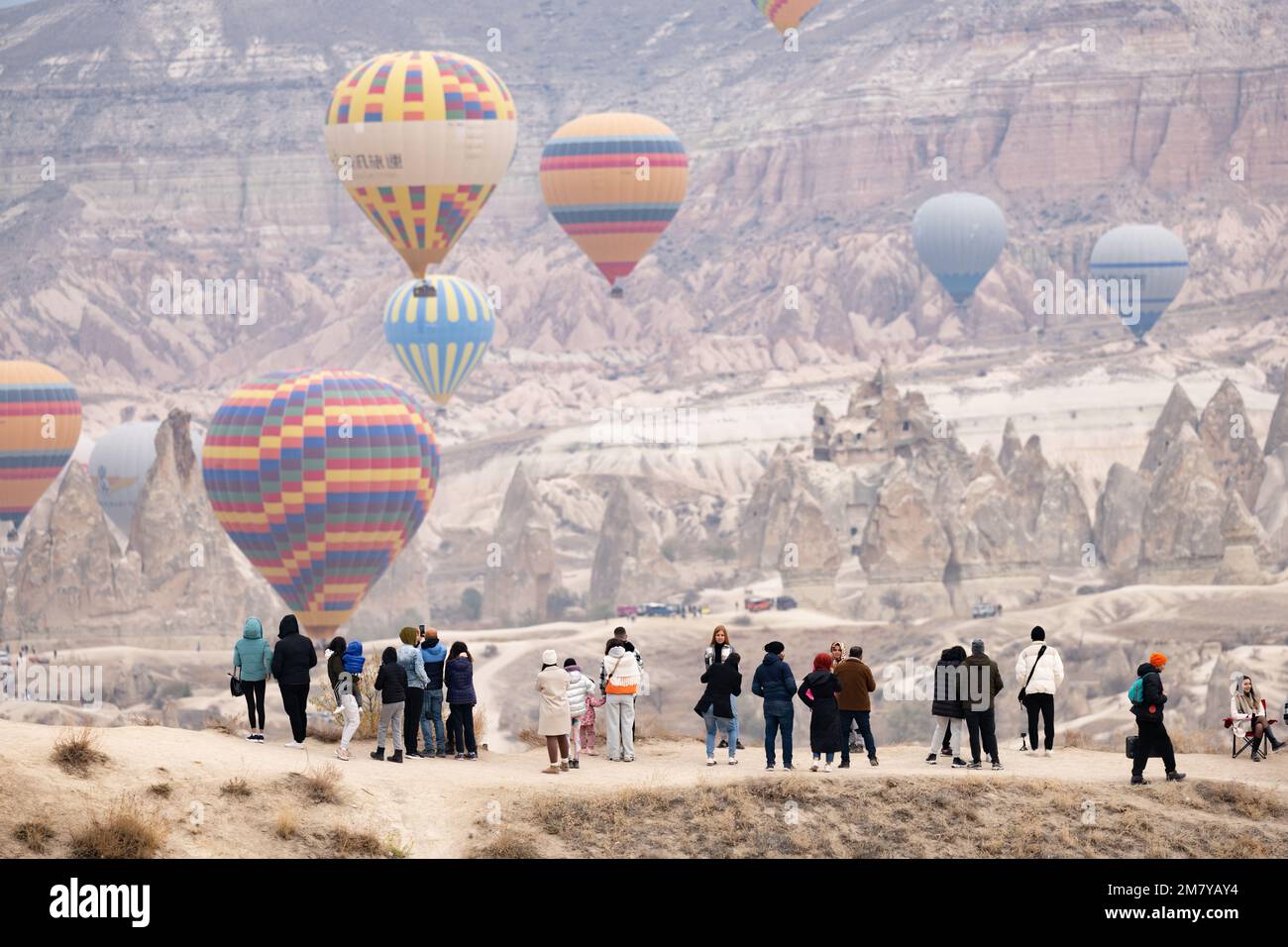 Stunning view some people admiring some hot air balloons flying over ...