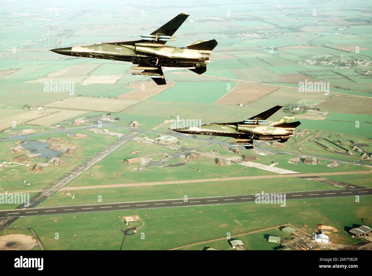 An air-to-air left underside view of two F-111 aircraft flown by the ...