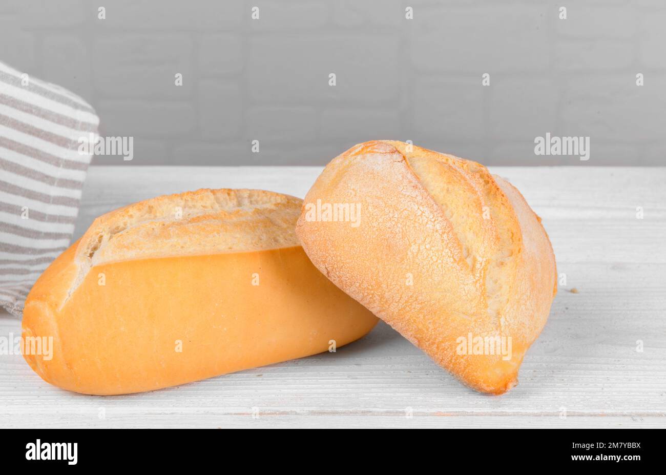 Fresh italian wheat breads on the table on white wall background, close ...