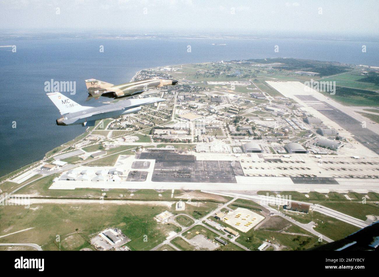 An air-to-air right side view of an F-4 Phantom II (background) and an ...