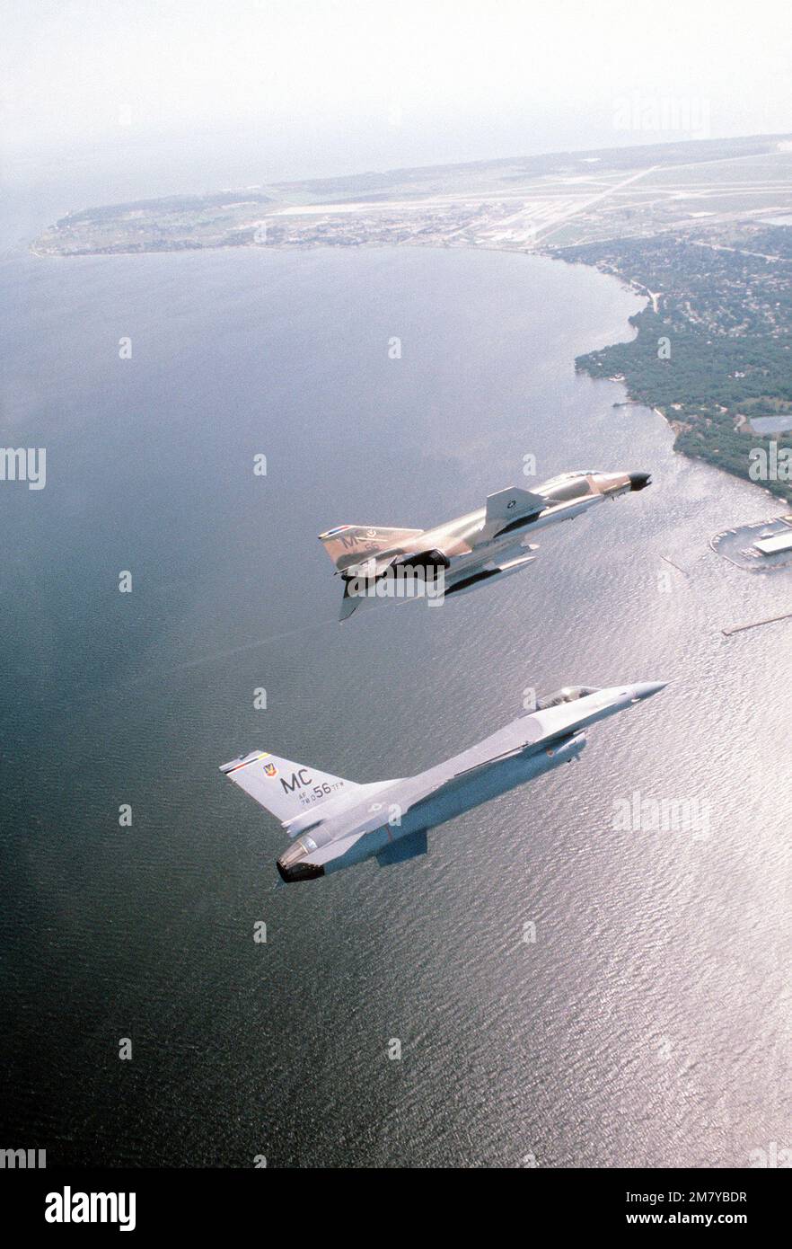 An air-to-air right side view of an F-4 Phantom II (background) and an ...