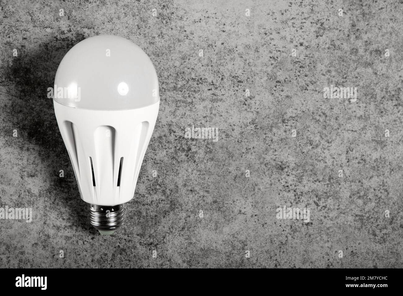 LED energy-saving lamp with E27 screw cap base on gray background with ...