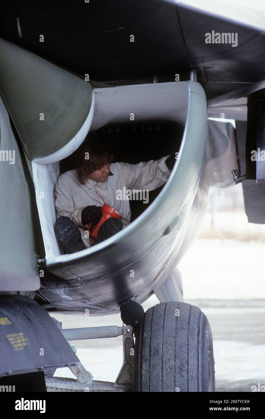 A ground crew chief inspects the intake of an F-111A aircraft. The ...