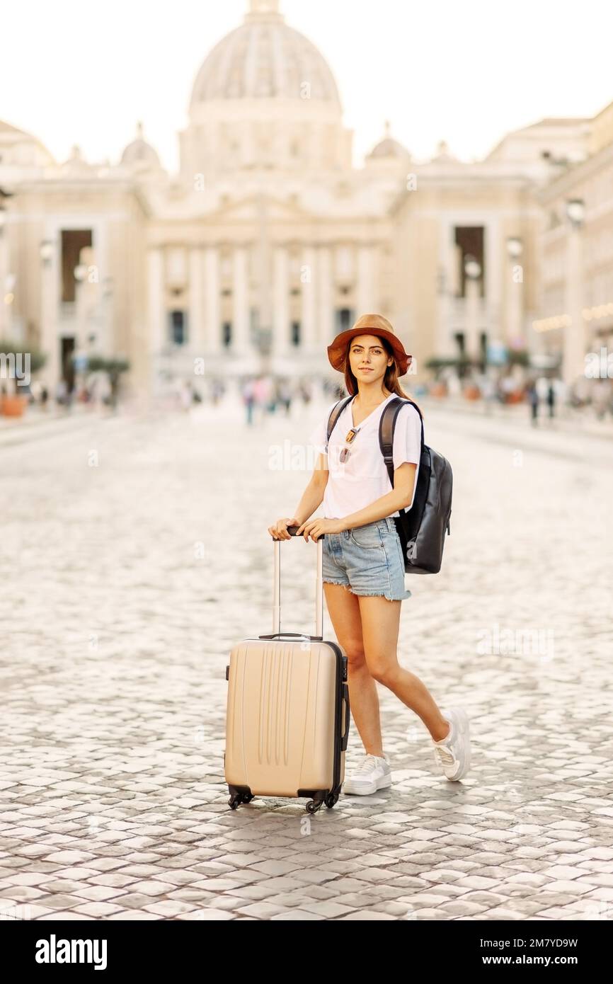 Portrait a female traveler wearing hat with a backpack and looks at the ...