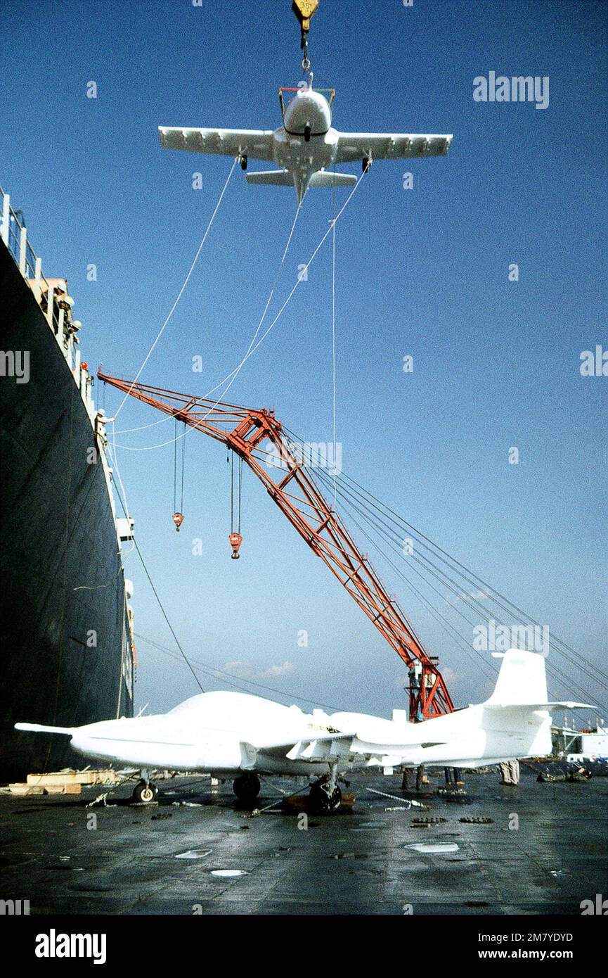 A floating crane lowers the second A-37 Dragonfly aircraft from the ...