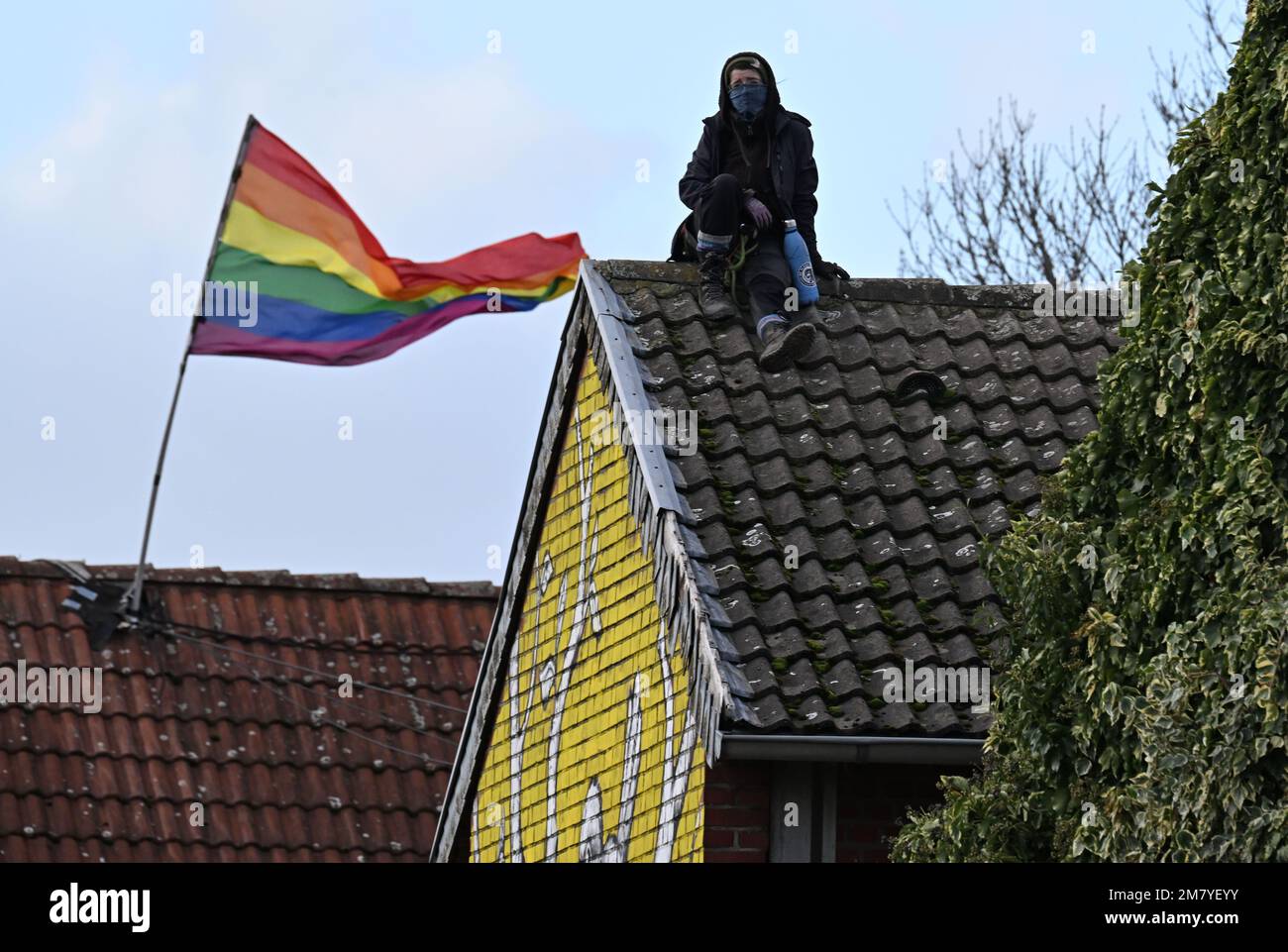Erkelenz, Germany. 11th Jan, 2023. A demonstrator sits on the gable of ...