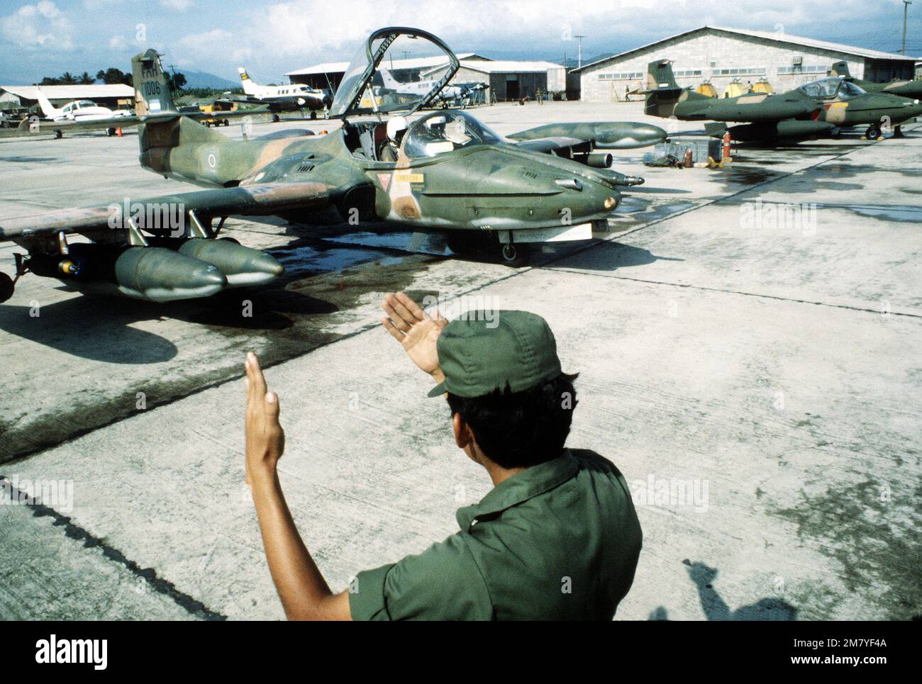 A Honduran Air Force (HAF) ground crewman signals taxiing directions to ...