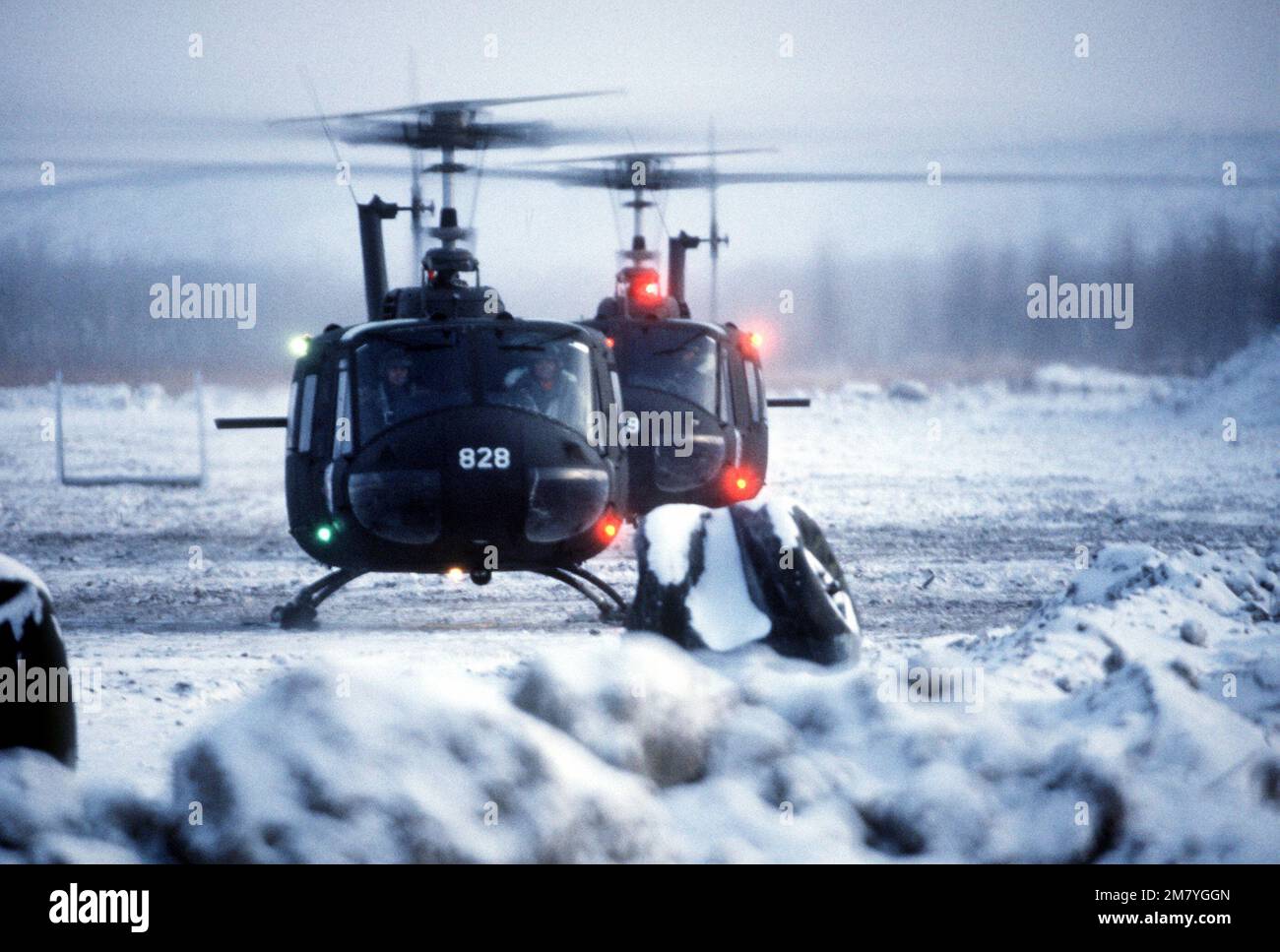 A front view of two UH-1 Iroquois helicopters landing to pick up ...