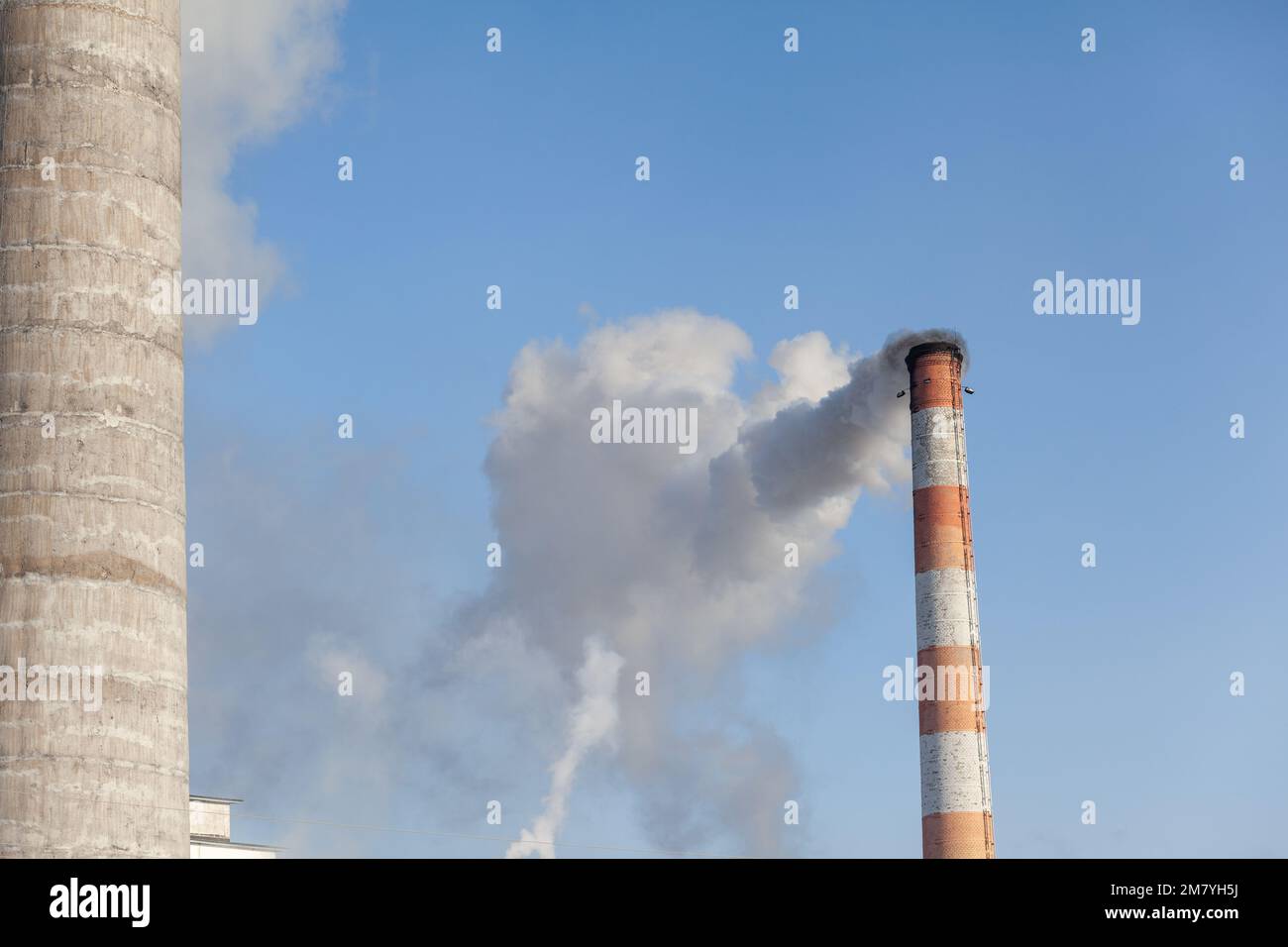 White thick smoke from the boiler room chimney. Smoke against the blue ...