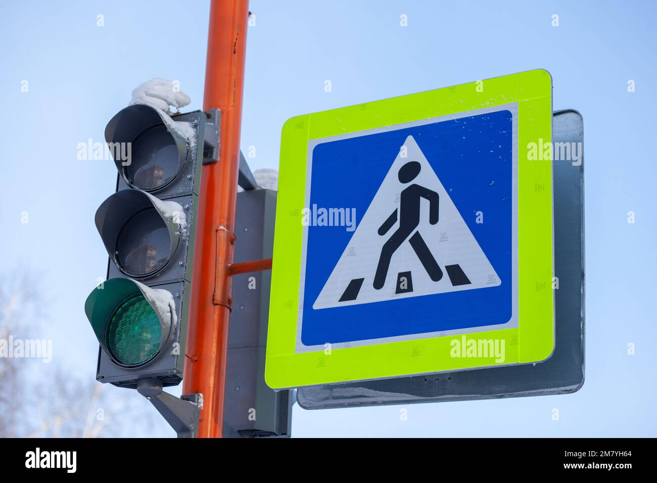 A pedestrian crossing sign with a reflective coating and a traffic ...