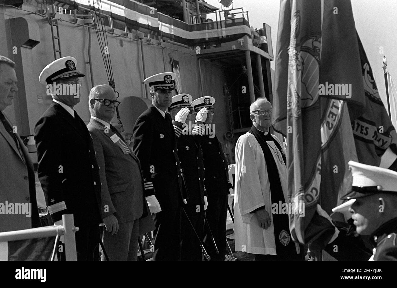 Distinguished guests on the speakers platform stand to view the color ...