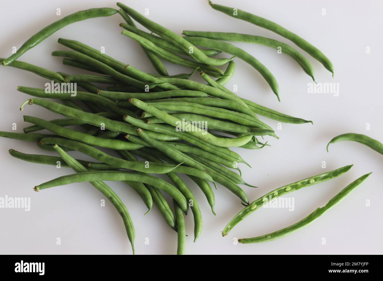 Bunch of French Beans shot on white back ground with few sliced half ...