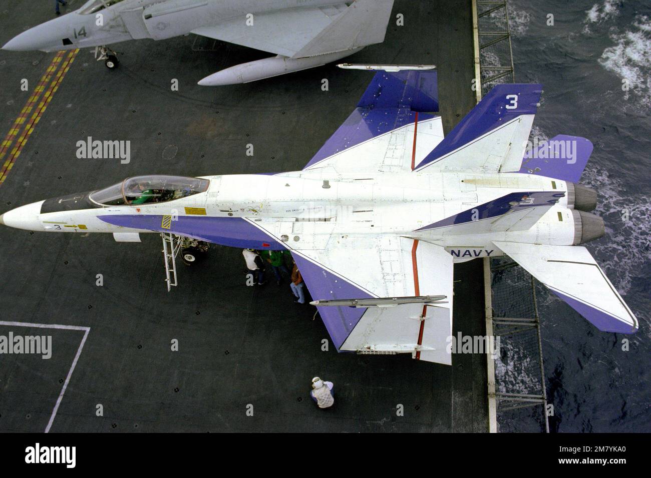 An overhead view of an F/A-18A Hornet aircraft secured at the edge of ...