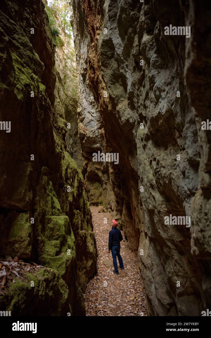 Hiker inside the Avencs de la Febró, a fissure about 30 meters deep in ...