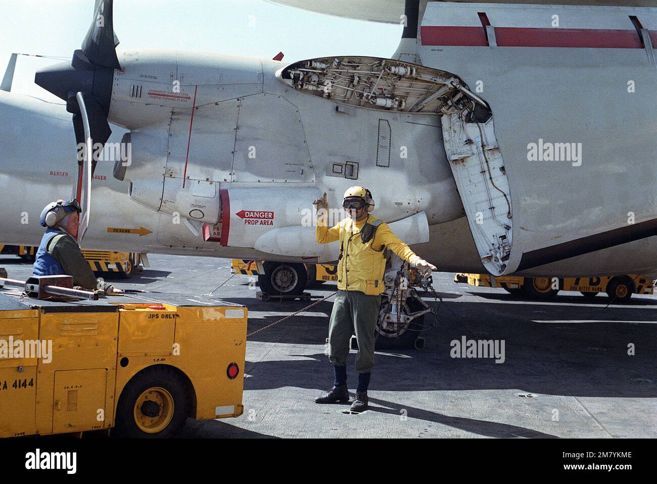 Crewmembers use an MD-3 tow tractor to move aircraft on the flight deck ...