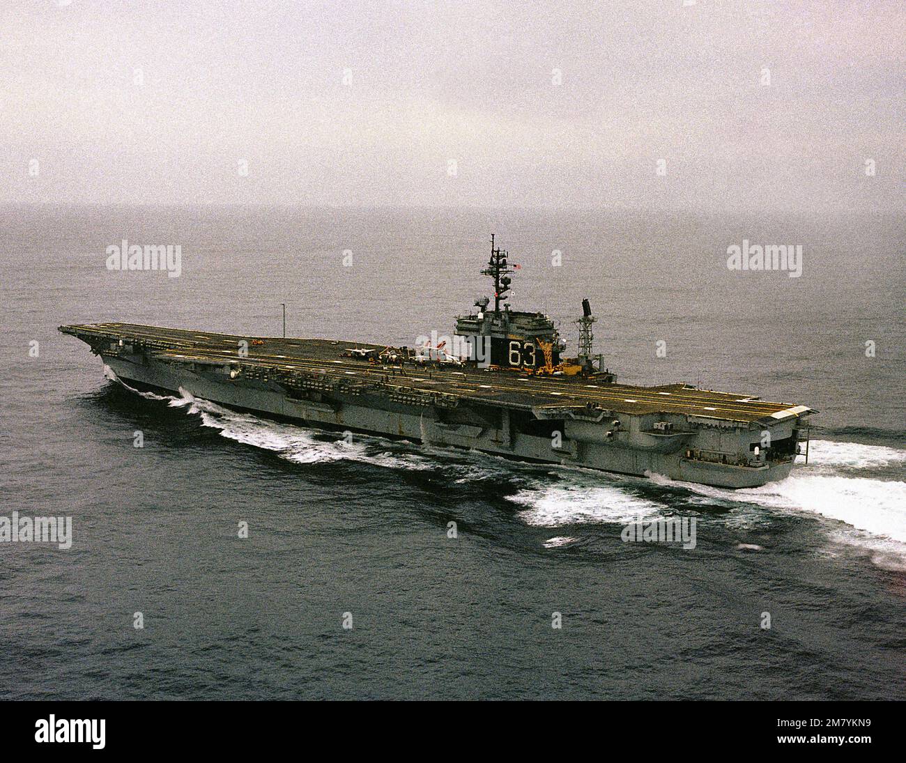 An aerial port quarter view of the aircraft carrier USS KITTY HAWK (CV ...