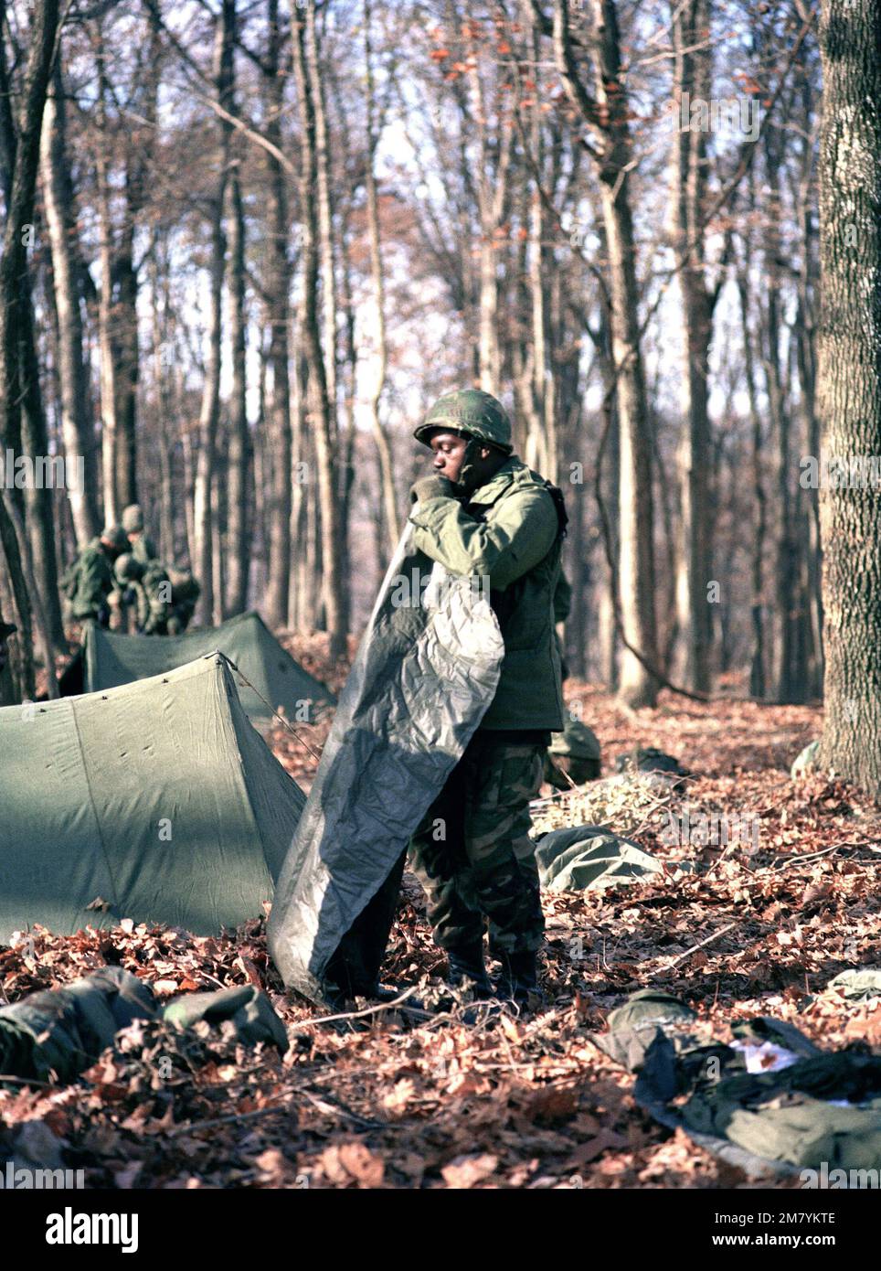 An infantryman inflates an air mattress during bivouac training at the ...