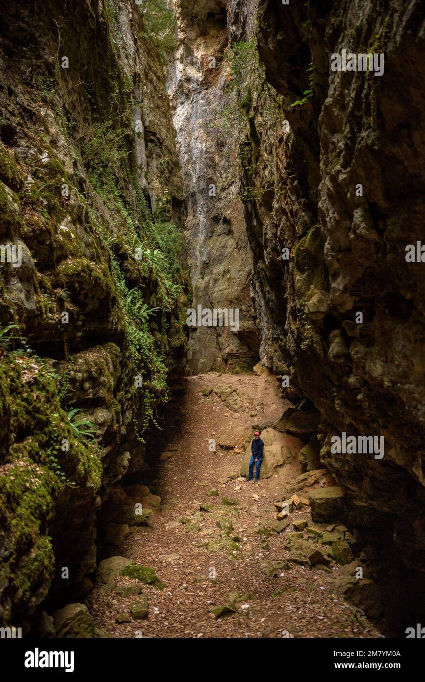 Hiker inside the Avencs de la Febró, a fissure about 30 meters deep in ...