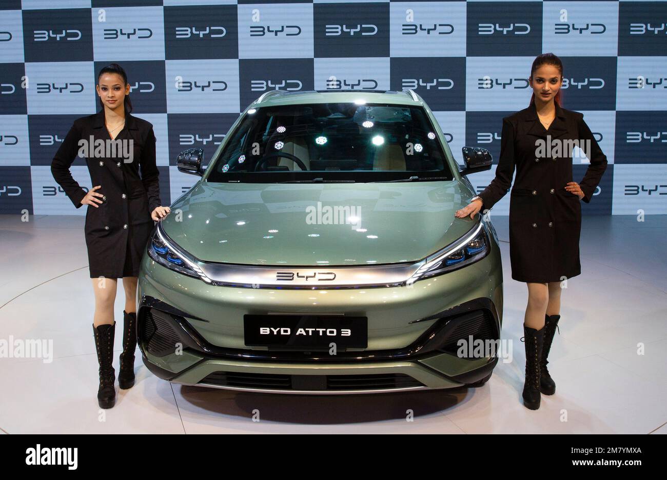 New Delhi, India. 11th Jan, 2023. Models stand next to a BYD Atto 3 car during the Auto Expo ...