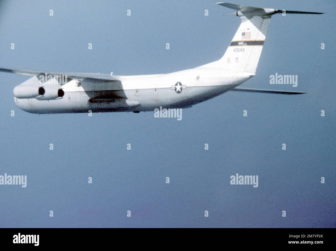 An air-to-air left rear view of a C-141B Starlifter aircraft from the ...