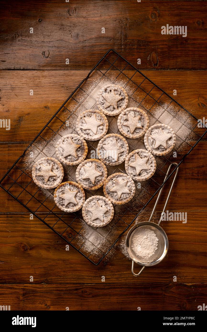 Flat lay mince pies topped with pastry stars, dusted with icing sugar ...