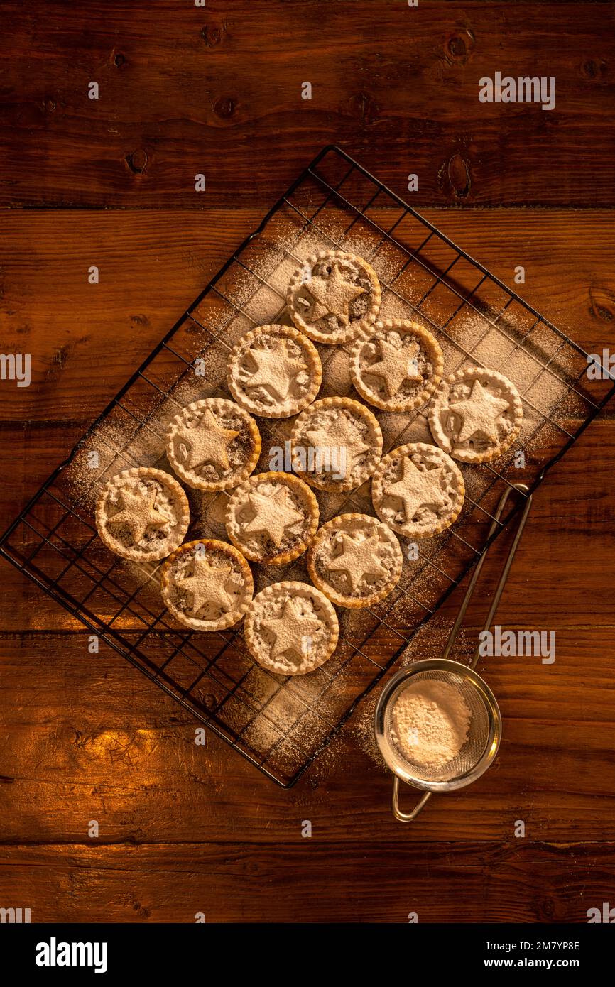 Flat lay mince pies topped with pastry stars, dusted with icing sugar ...