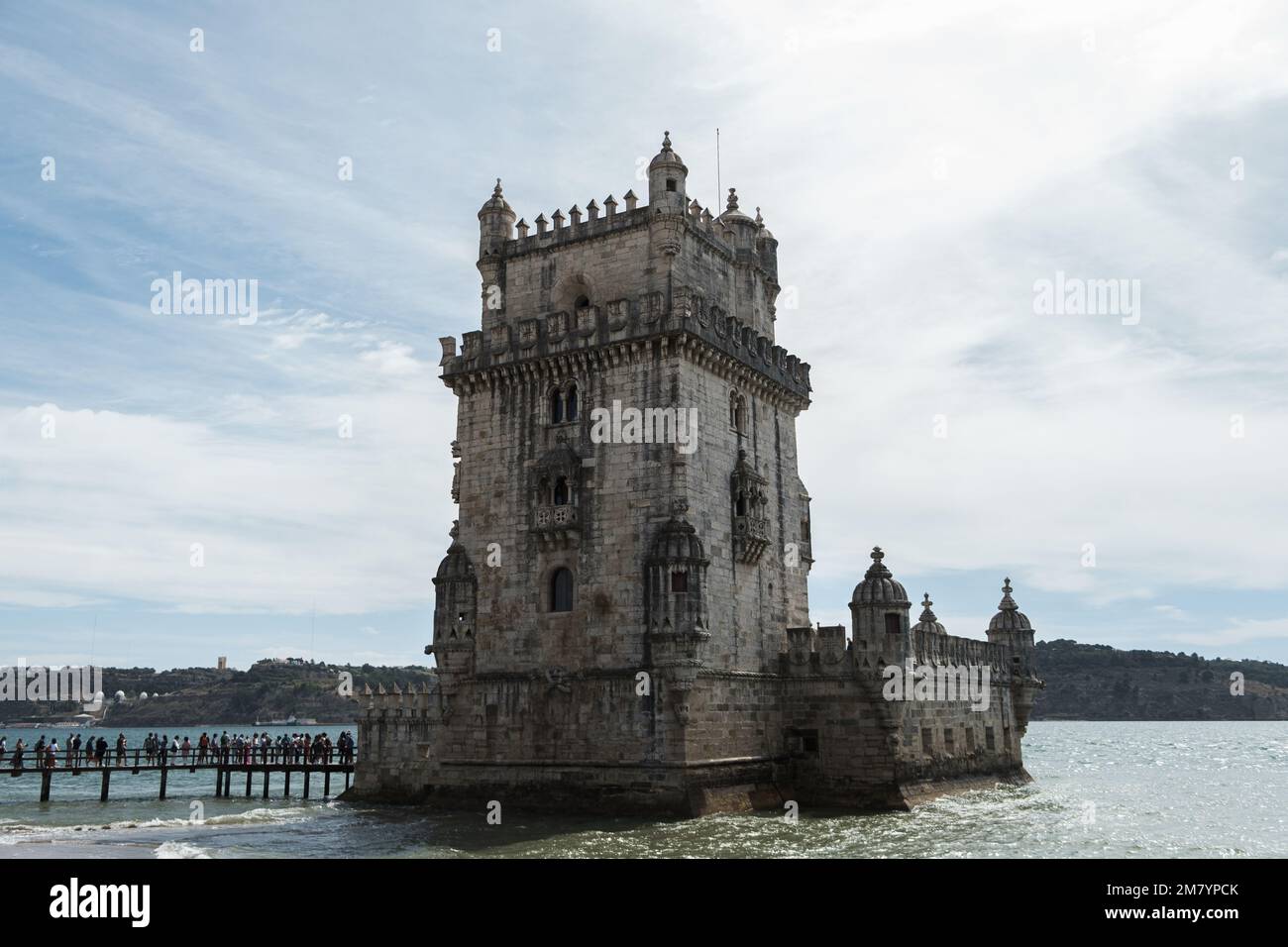 A low-angle of Belem tower with a seascape view with a cloudy, sunlit ...