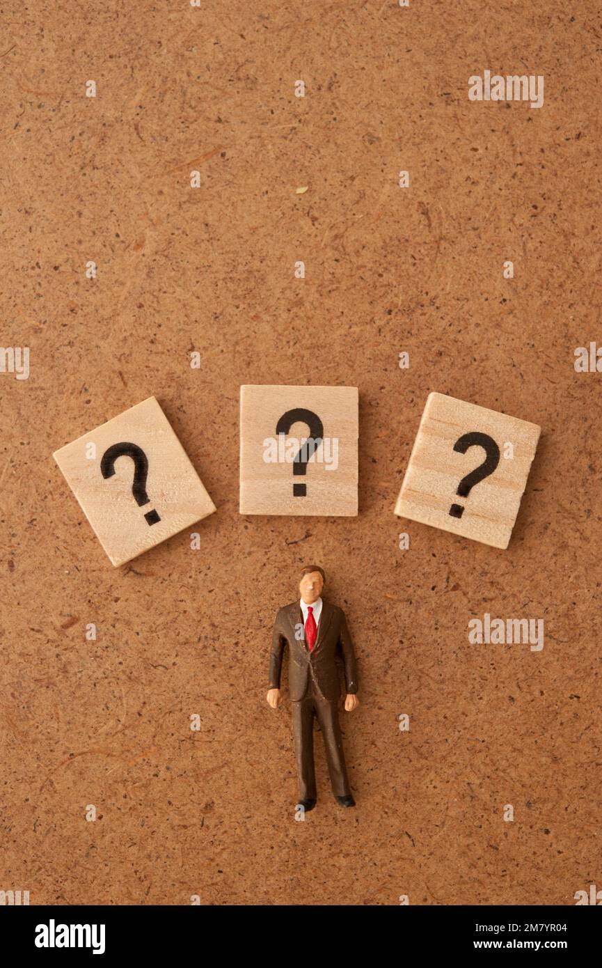 miniature figurine with question marks around him Stock Photo - Alamy