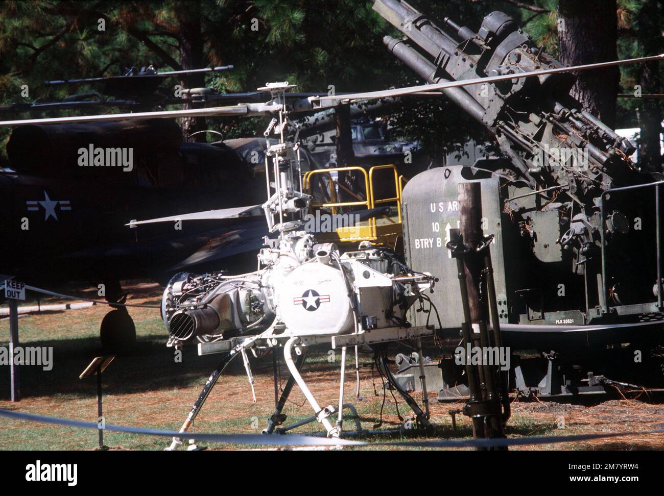 A remote control QH-50 drone helicopter on display beside an M118 90 mm ...