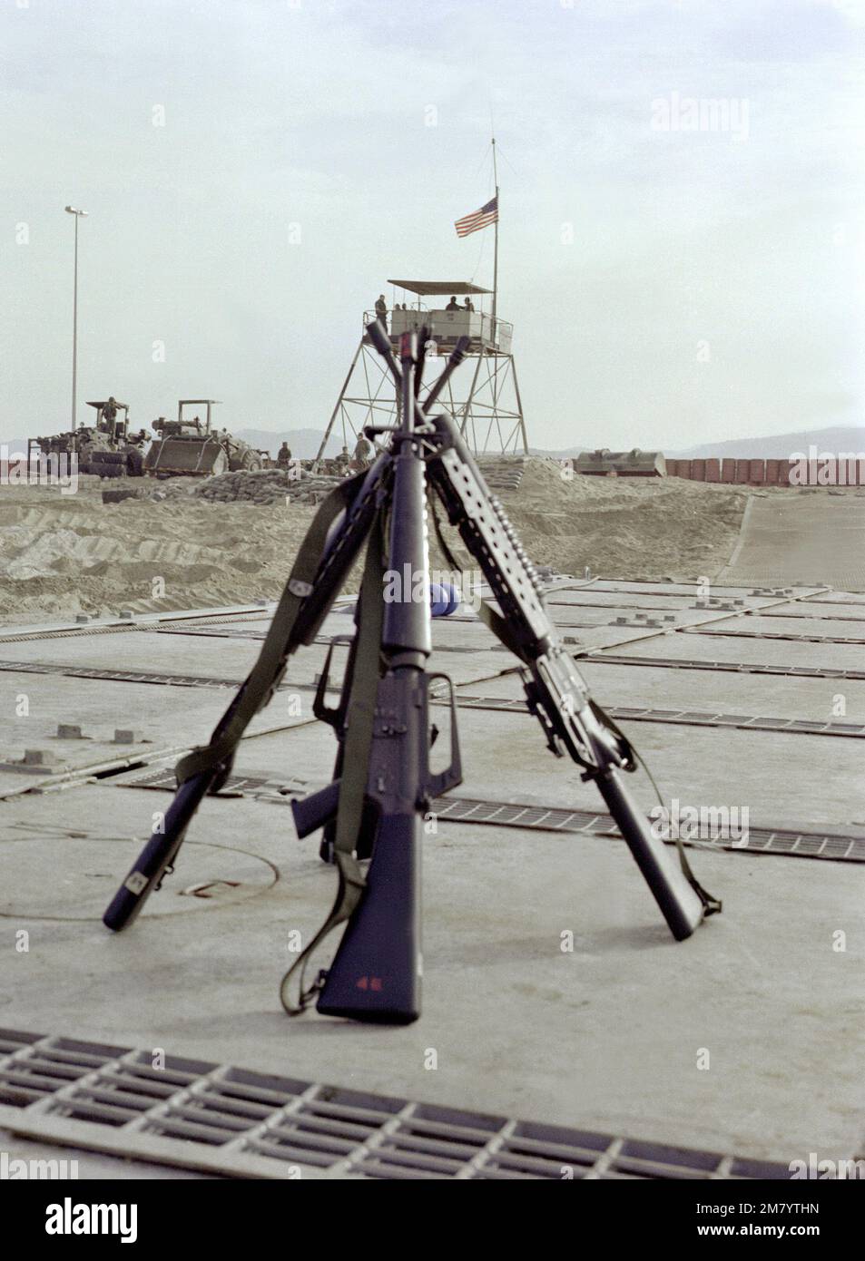 M-16 rifles stand stacked on a causeway at a U.S. Marine beachfront ...