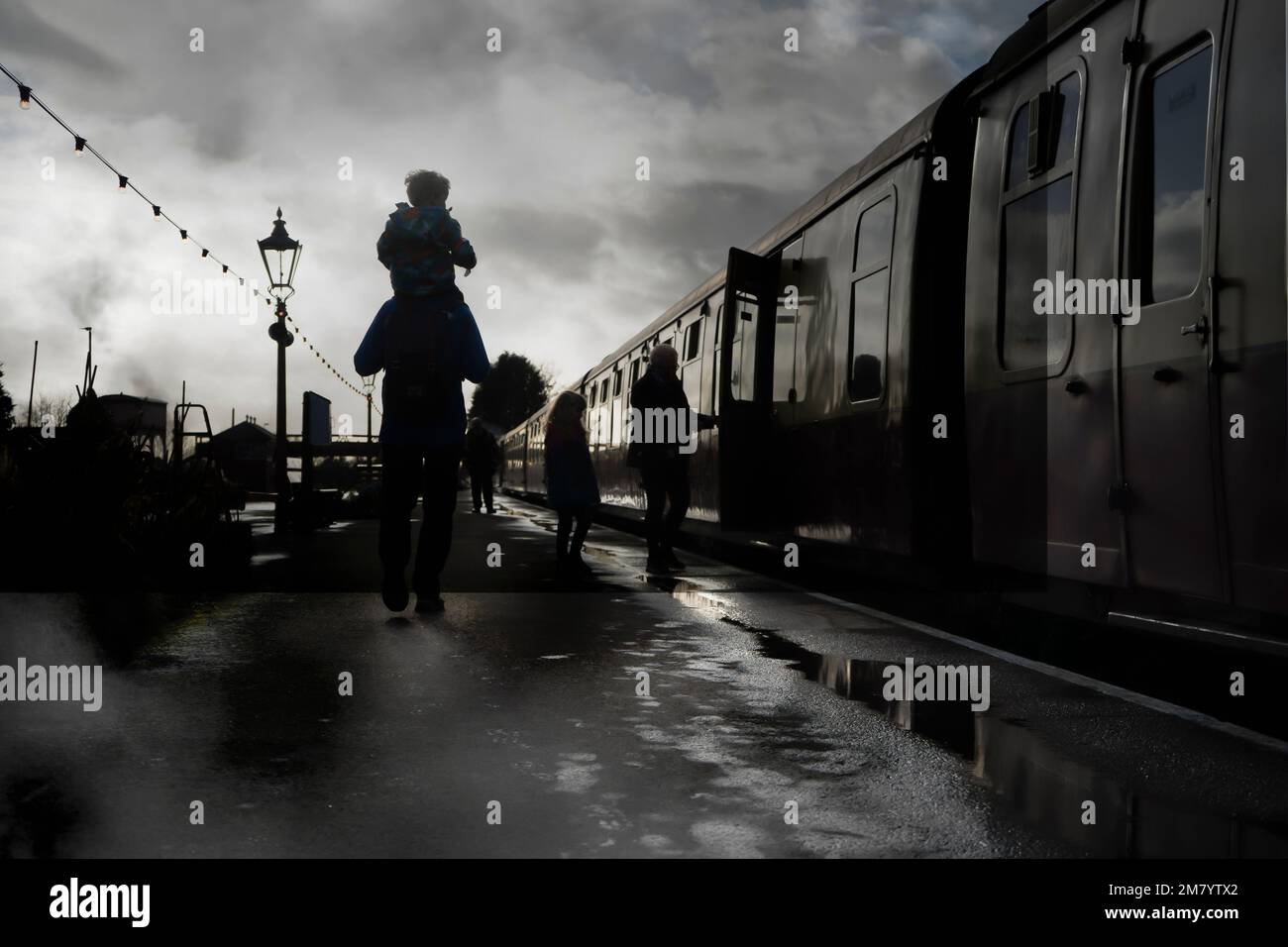 Silhouette of man with child on his shoulders walking along the ...