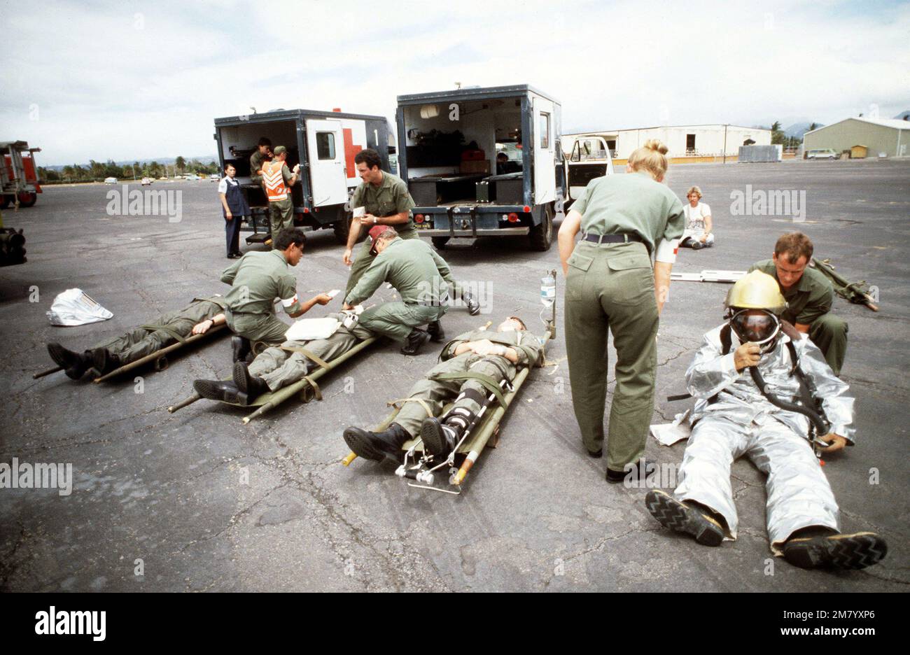 Medical personnel attend to "injured" crewman and firefighters during a ...