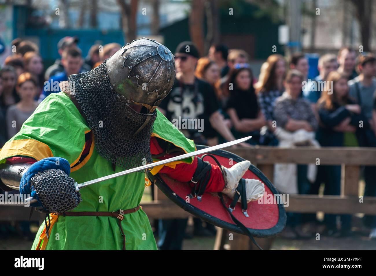 Medieval restorers fight with swords in armor at a knightly tournament ...
