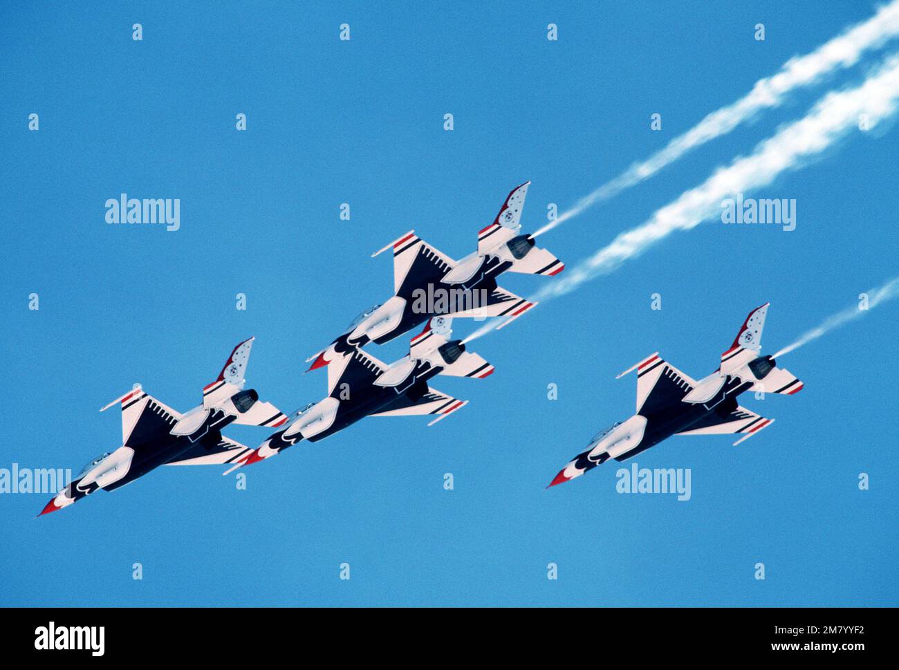 An air-to-air left underside view of four F-16 Fighting Falcon aircraft ...