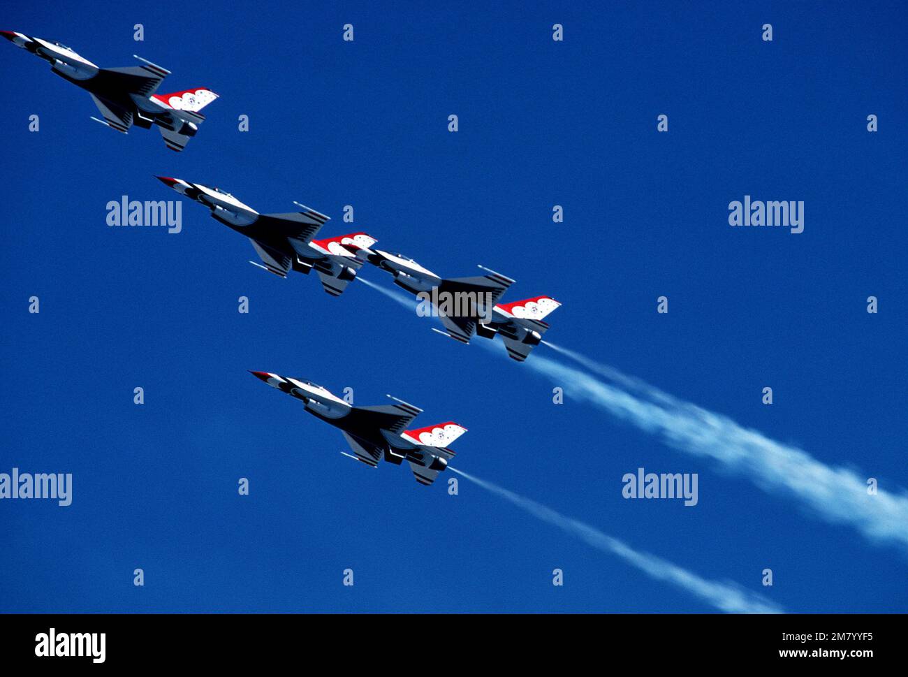 An air-to-air left side view of four F-16 Fighting Falcon aircraft in ...