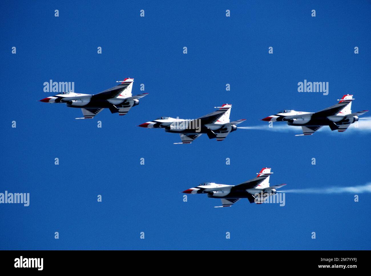 An air-to-air left side view of four F-16 Fighting Falcon aircraft in ...