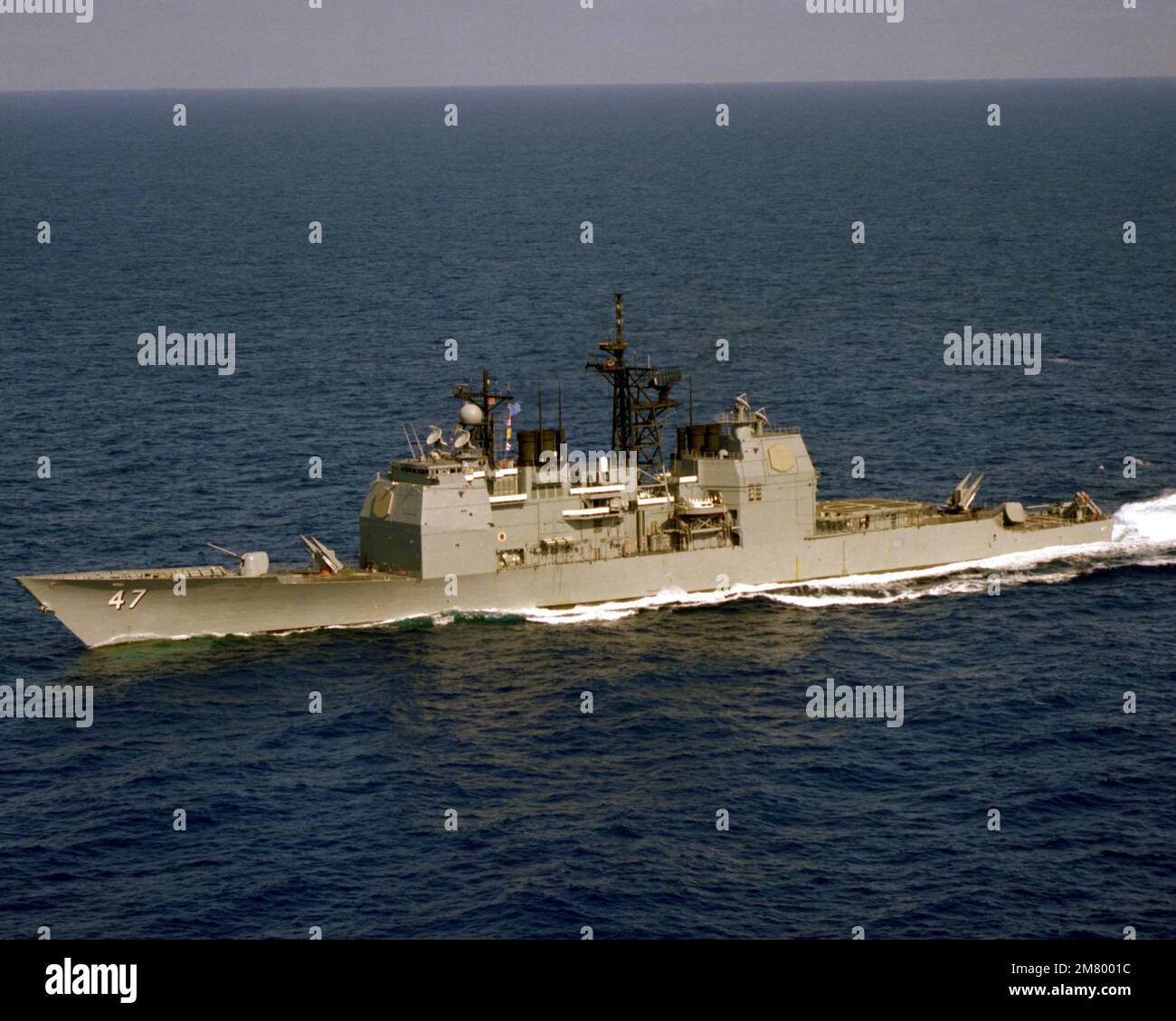 An aerial port view of the Aegis guided missile cruiser USS TICONDEROGA ...