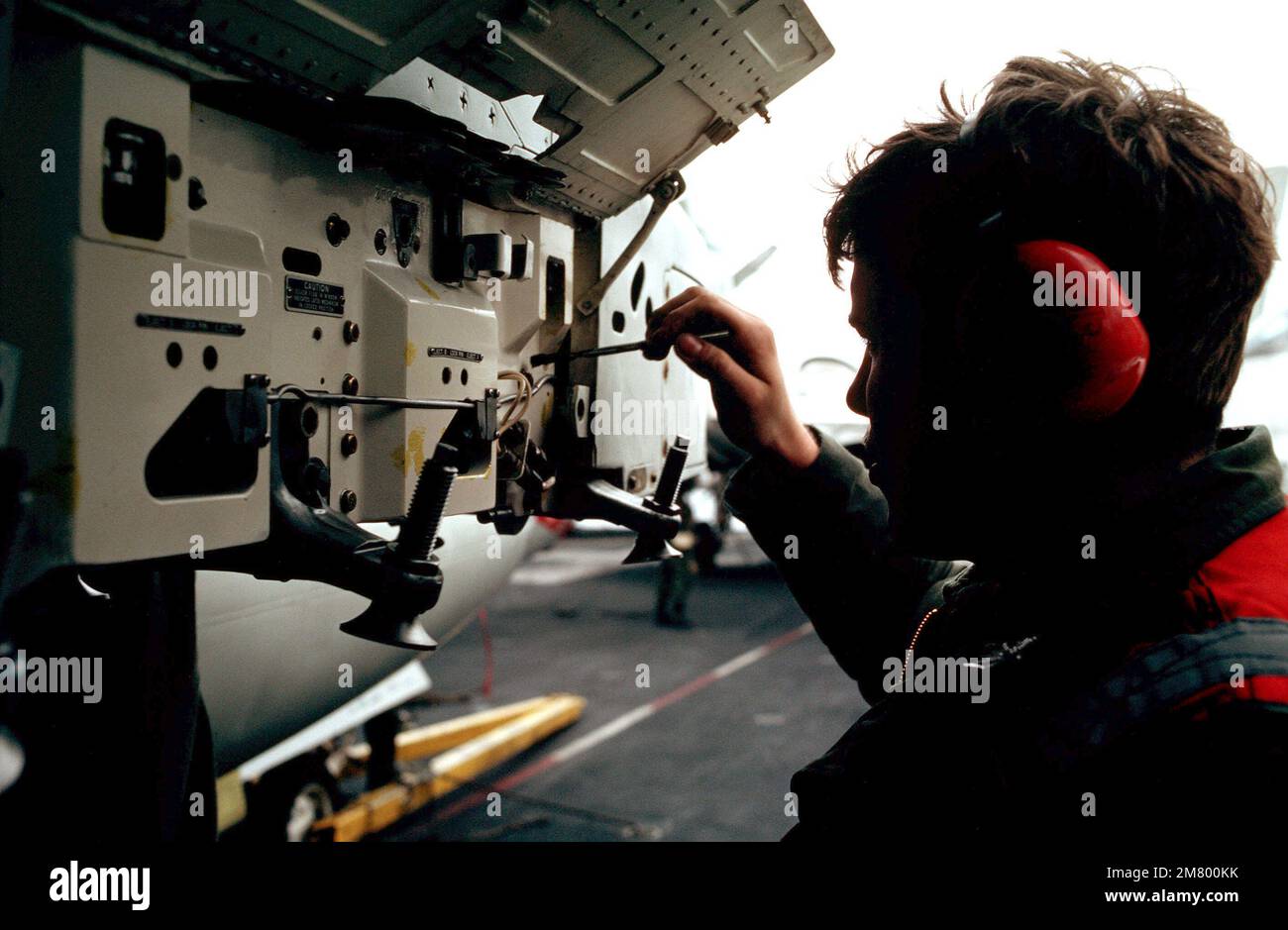 A crewman aboard the aircraft carrier USS MIDWAY (CV 41) services an ...