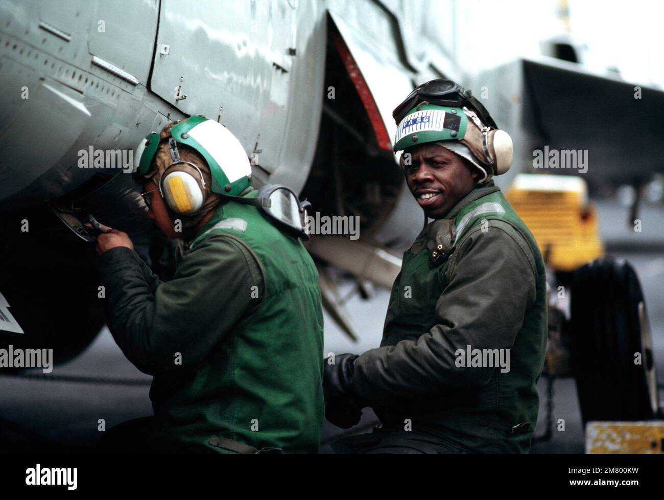 Crewmen aboard the aircraft carrier USS MIDWAY (CV 41) service an ...