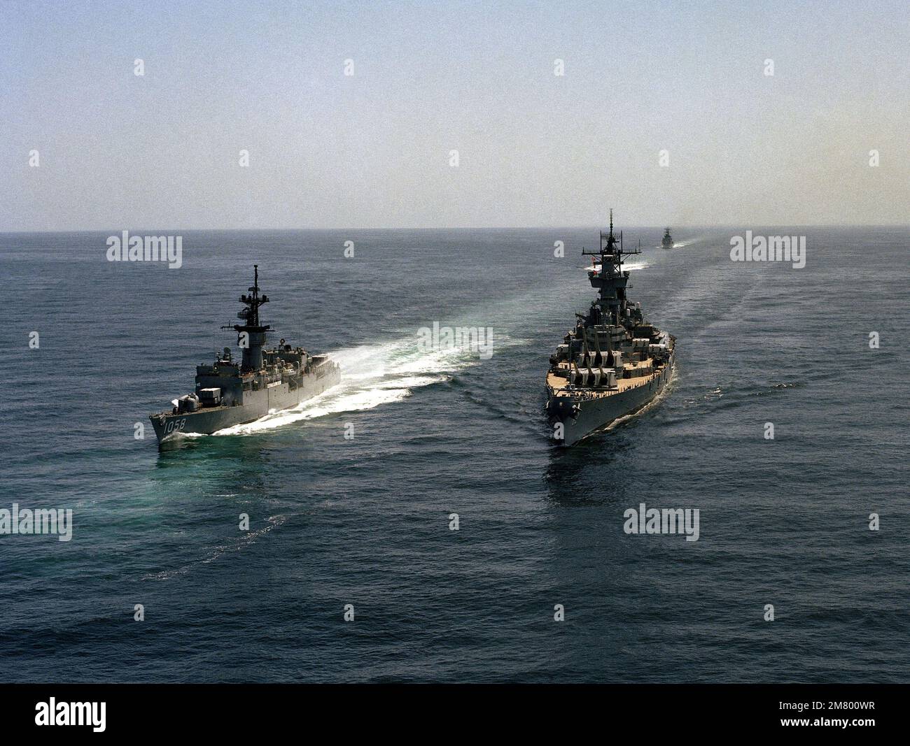 An aerial port bow view of the battleship USS NEW JERSEY (BB 62) and ...