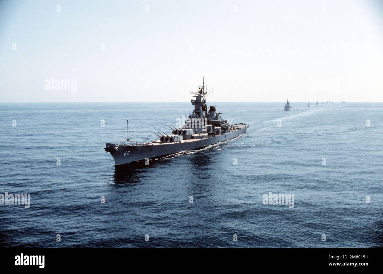 Aerial port bow view of the battleship USS NEW JERSEY (BB 62) leading ...