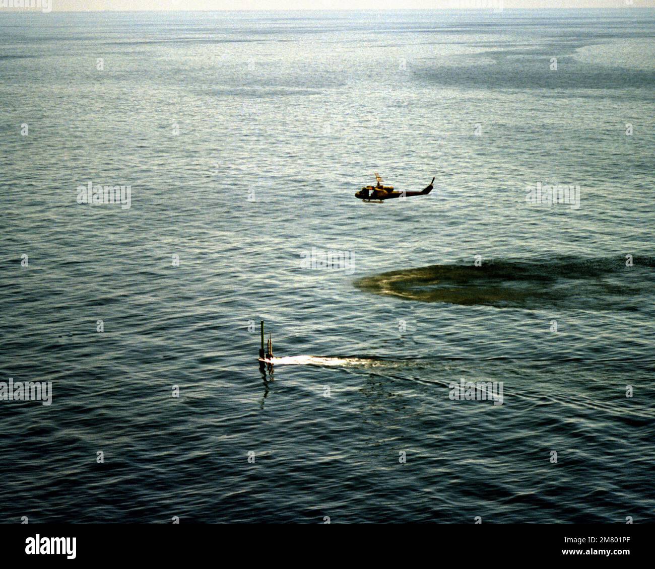 A UH-1 Iroquois helicopter flies over the nuclear-powered attack ...