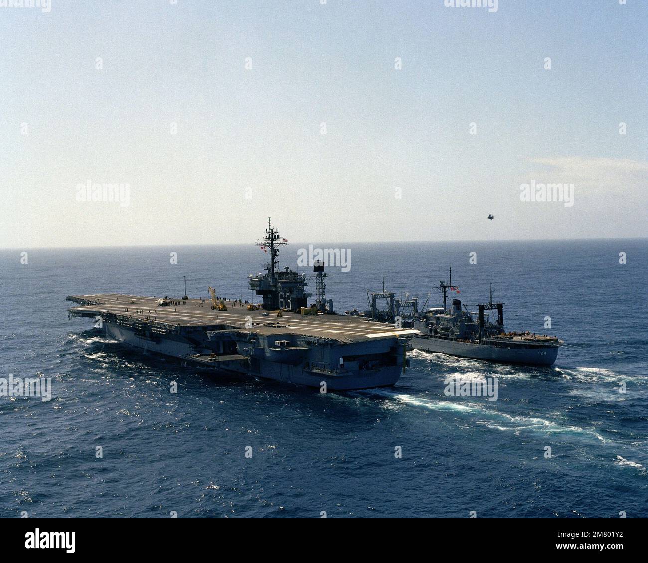 Aerial port quarter view of the aircraft carrier USS KITTY (CV 63) and ...