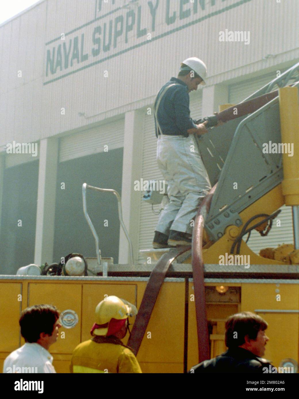 A firefighter prepares to climb a ladder during efforts to extinguish a ...
