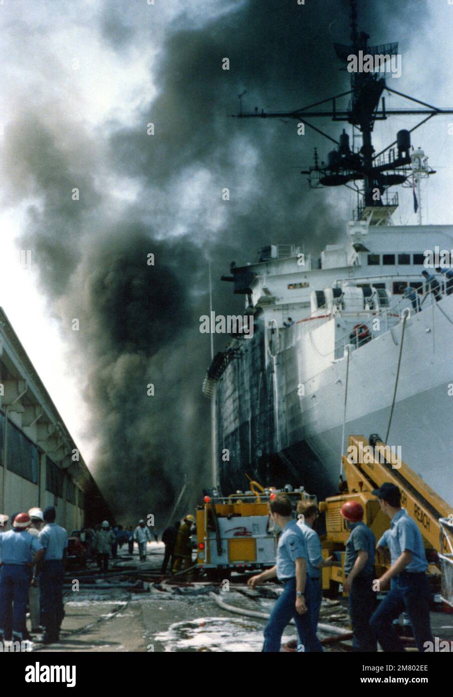 Firefighters at Pier 4 of the naval station work to extinguish a fire ...