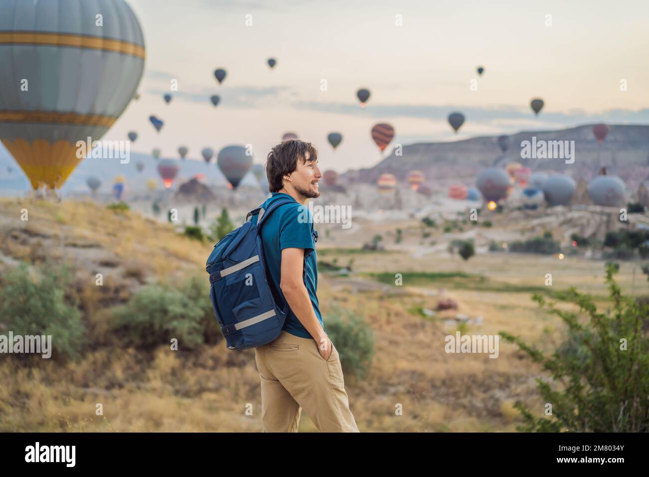 Tourist man looking at hot air balloons in Cappadocia, Turkey. Happy ...