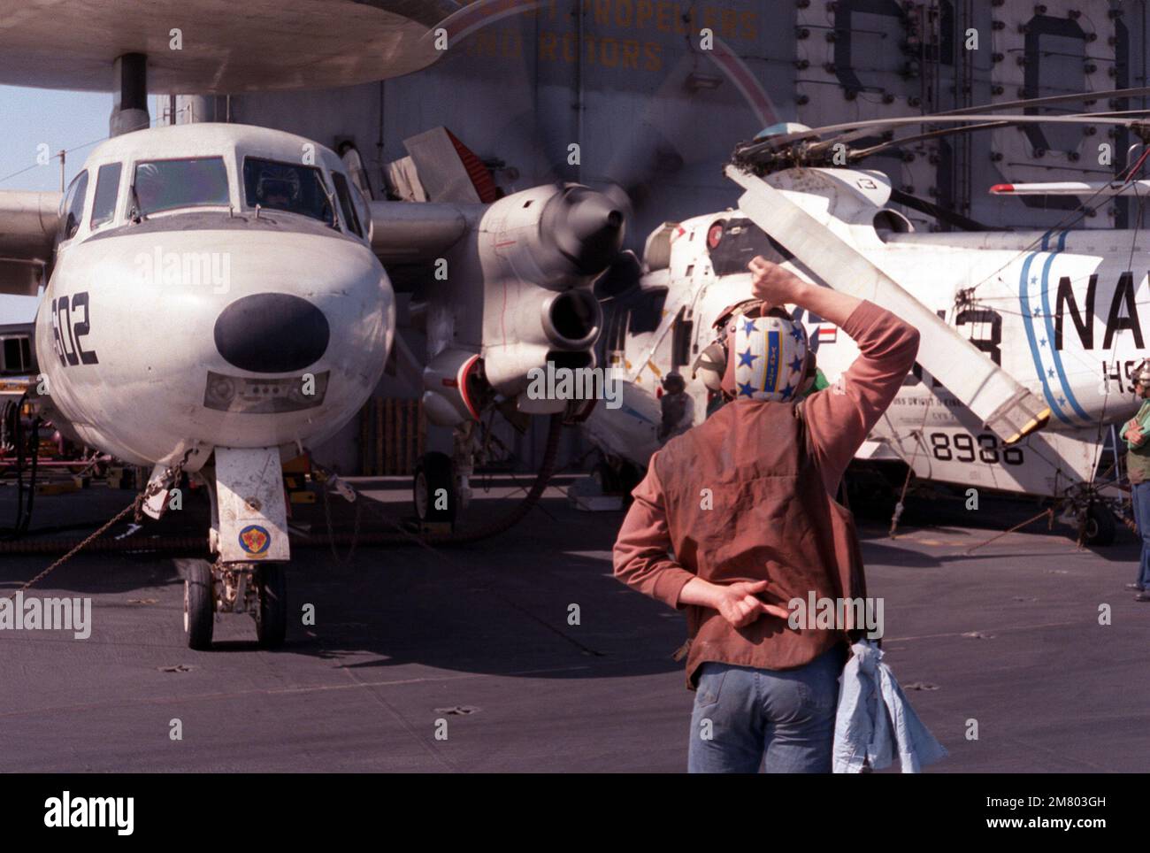 A flight deck crew member signals to the pilot of an Airborne Early ...