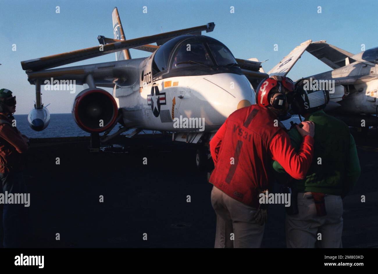 Members of Air Anti-submarine Squadron 31 (VS-31) stand by one of their ...