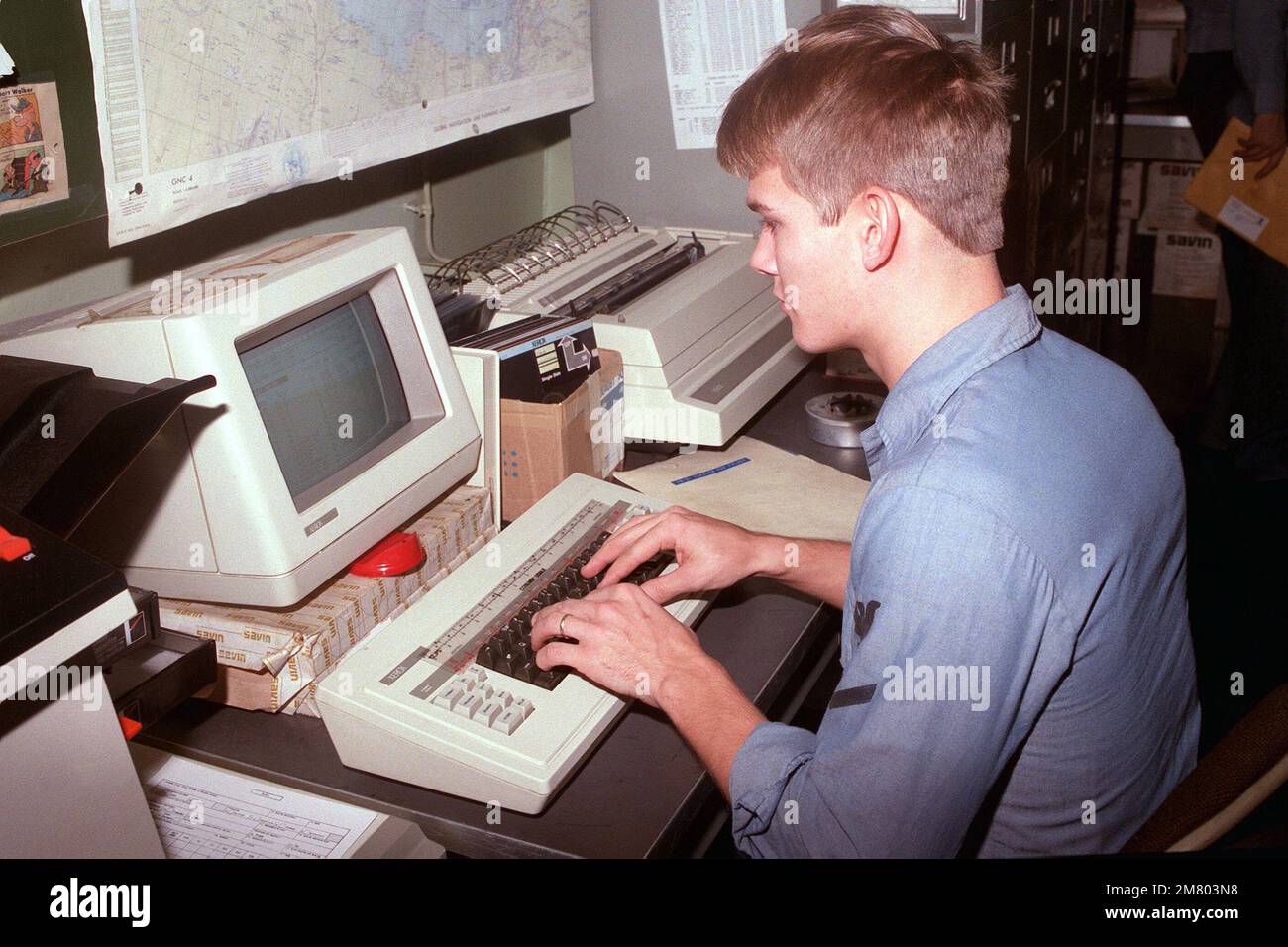 A crew member works on a computer aboard the nuclear-powered aircraft ...