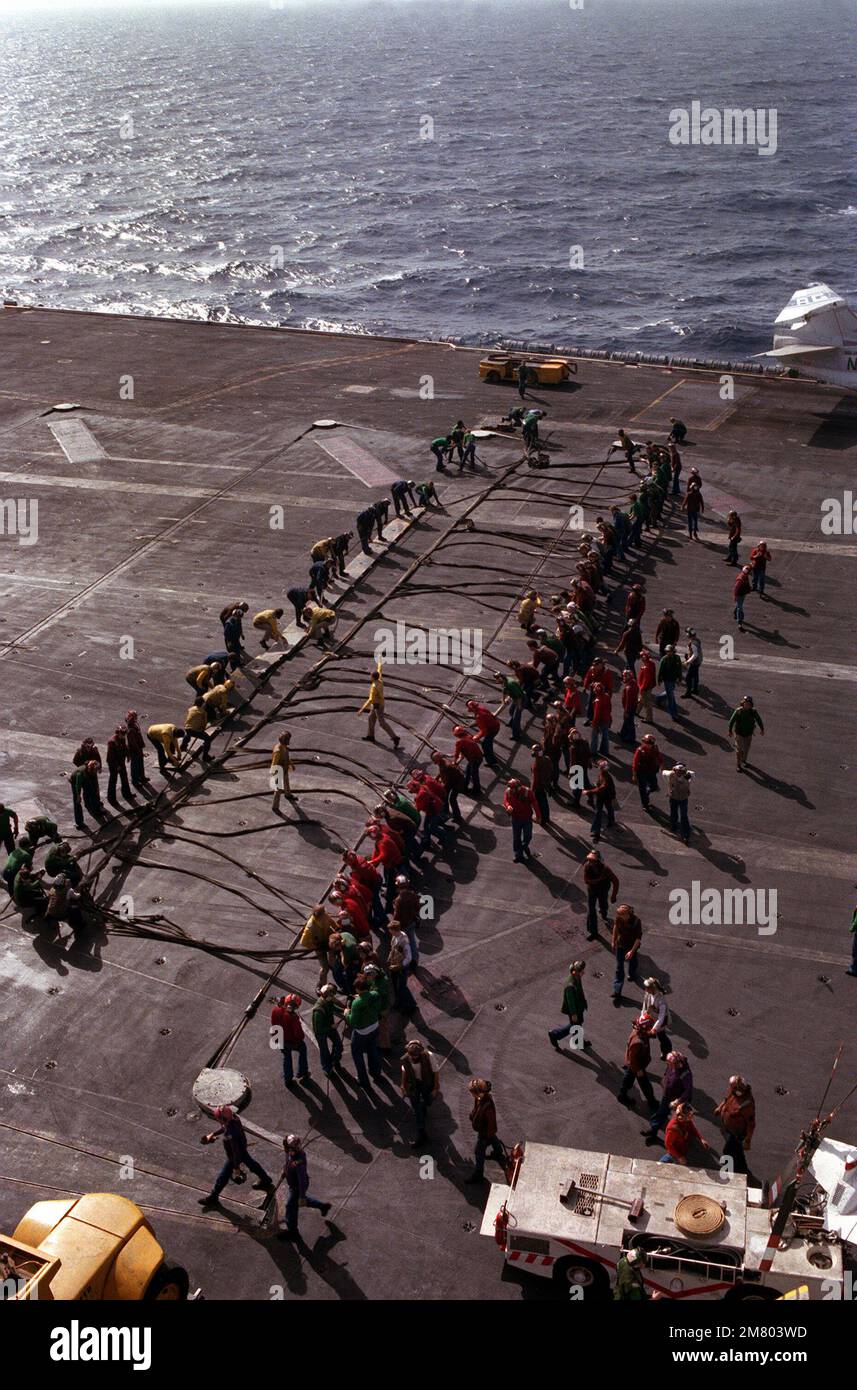 Flight deck crewmen practice erecting the crash barricade on the flight ...